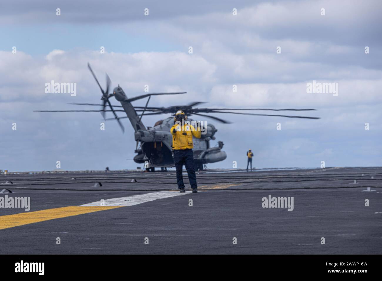 A U.S. Navy Sailor directs CH-53E Super Stallion helicopters with ...