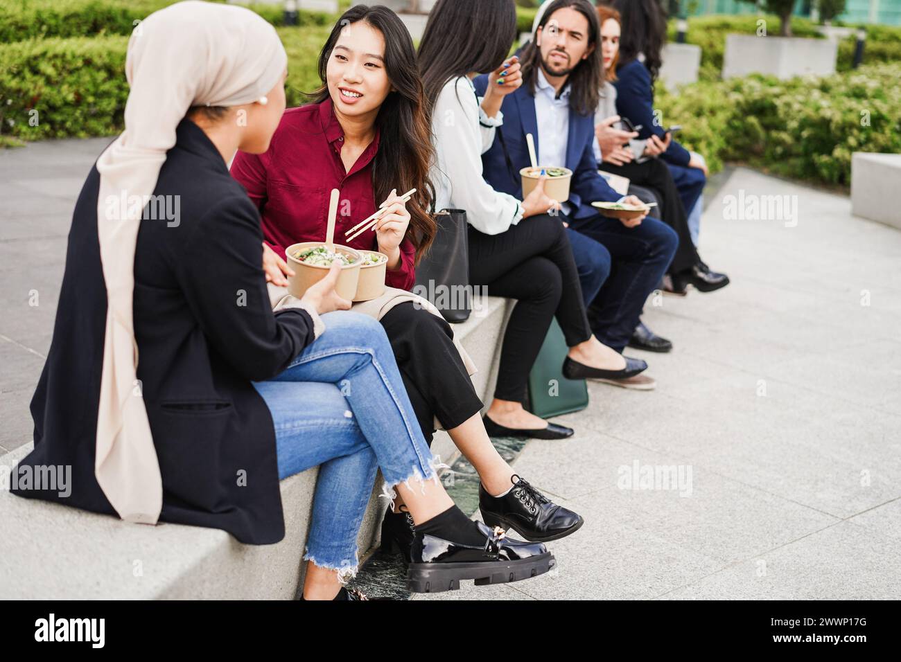 Multiethnic business people doing lunch break outside during spring ...