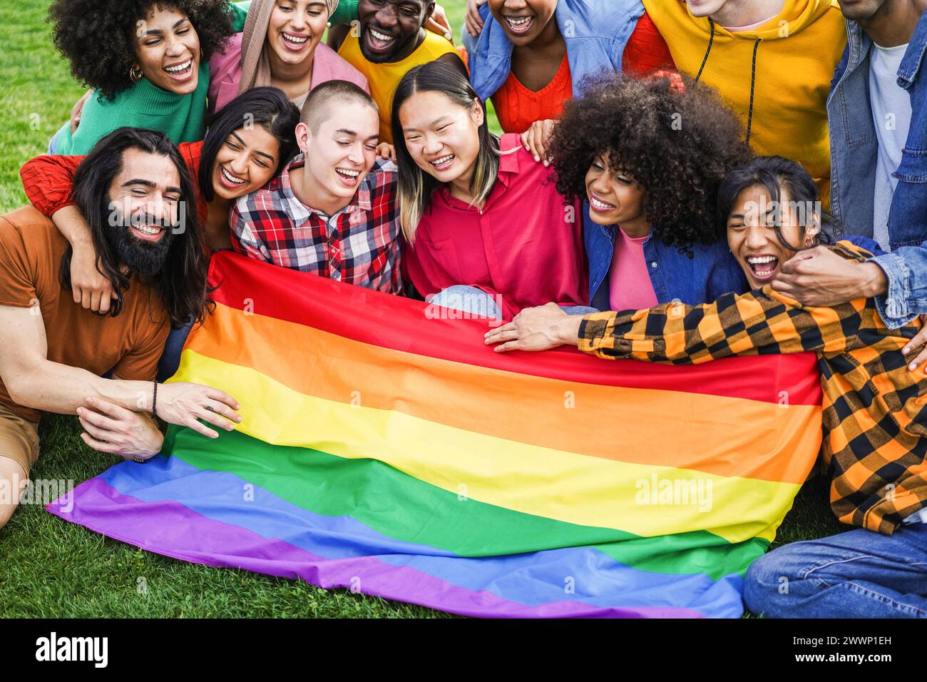 Diverse people having fun holding LGBT rainbow flag outdoor ...