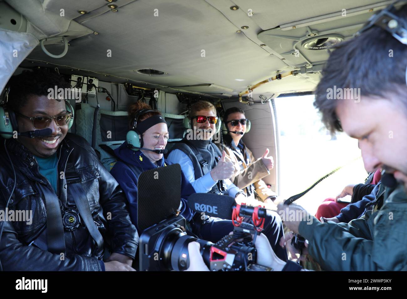 Representatives from local media outlets strap into a UH-60 Black Hawk ...