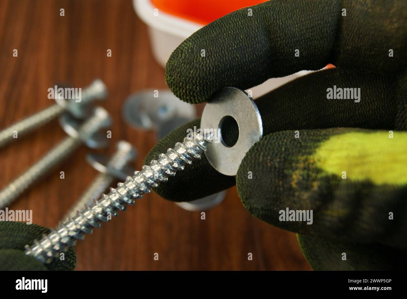 Stell washers and screw in the hands of the builder Stock Photo - Alamy