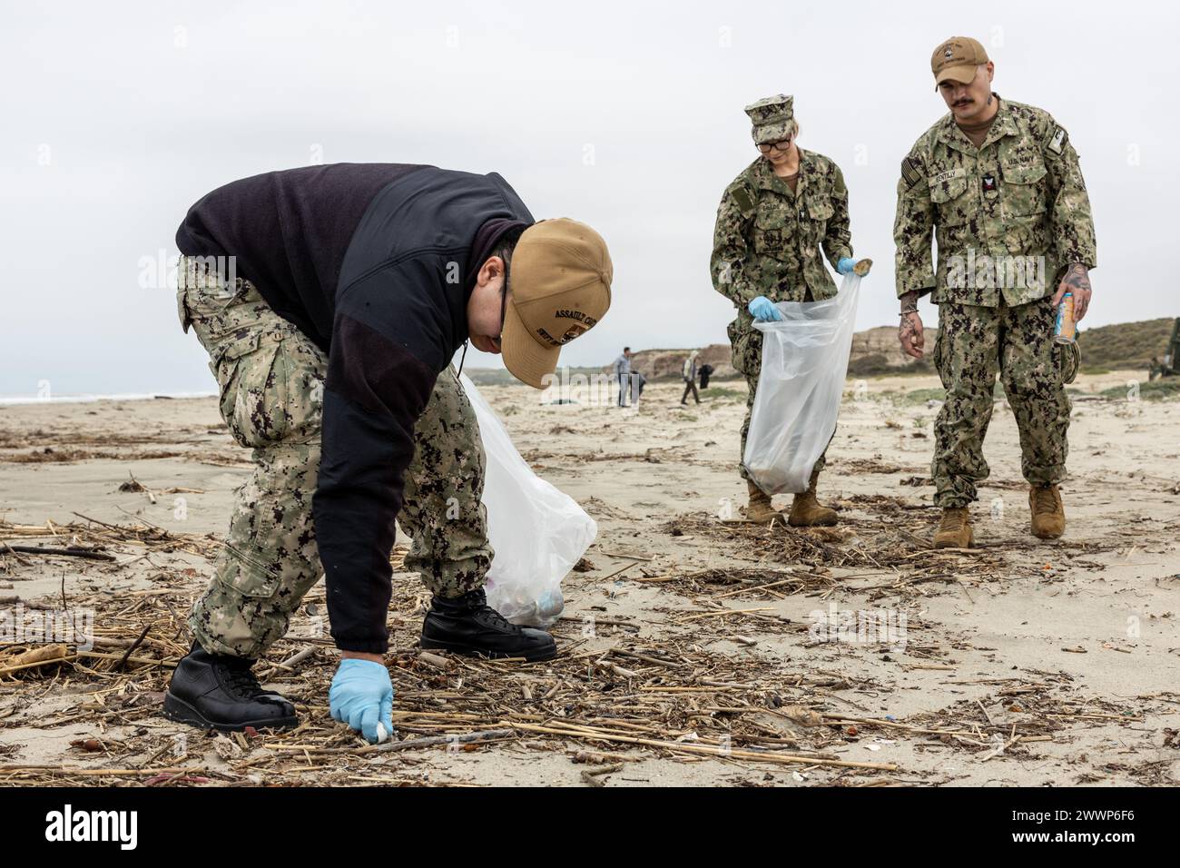 U.S. Navy sailors with Assault Craft Unit 5, collect trash during a ...