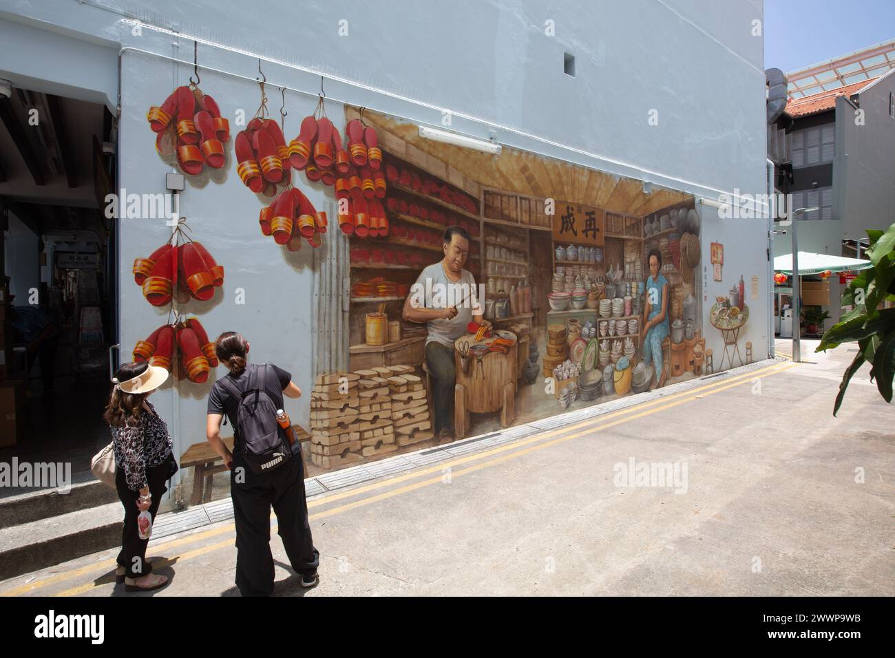 Two women explore the traditional art mural painted by artist Yip Yew ...