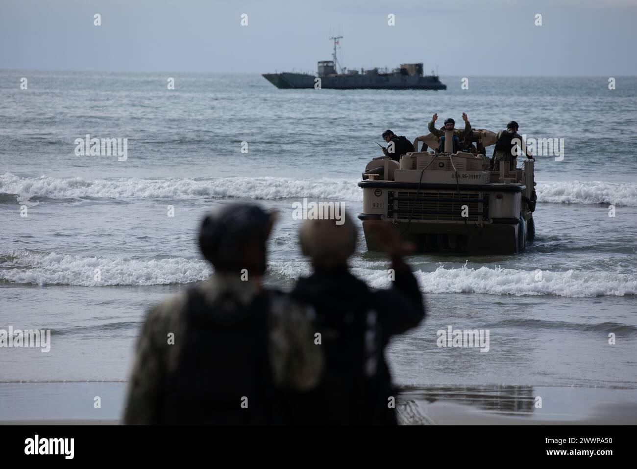 U.S. Navy Sailors, assigned to Beachmaster Unit 1, ground guide a ...
