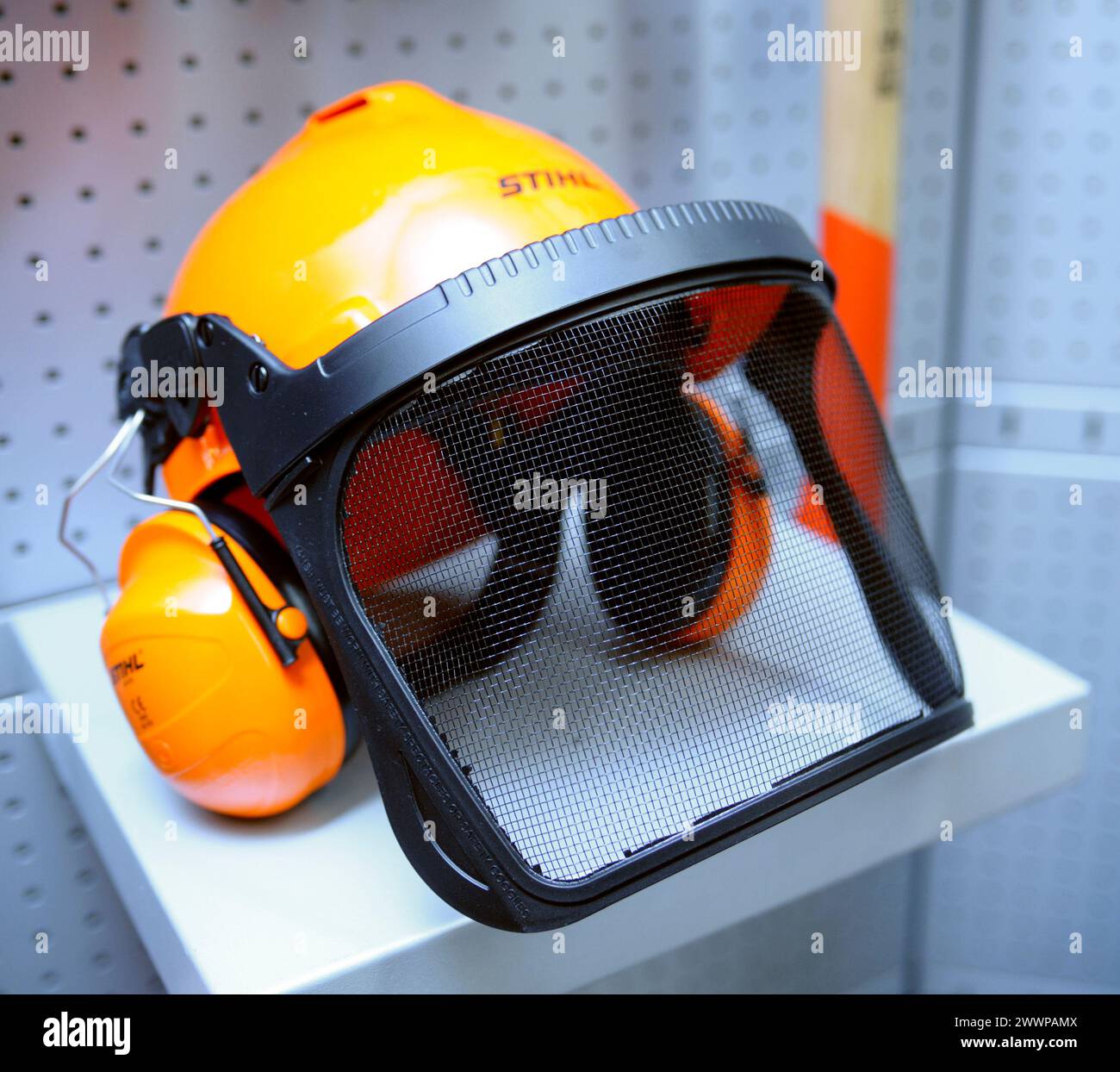 Modern function basic safety helmet system, earmuffs and mesh visor placed on stand, made by ...