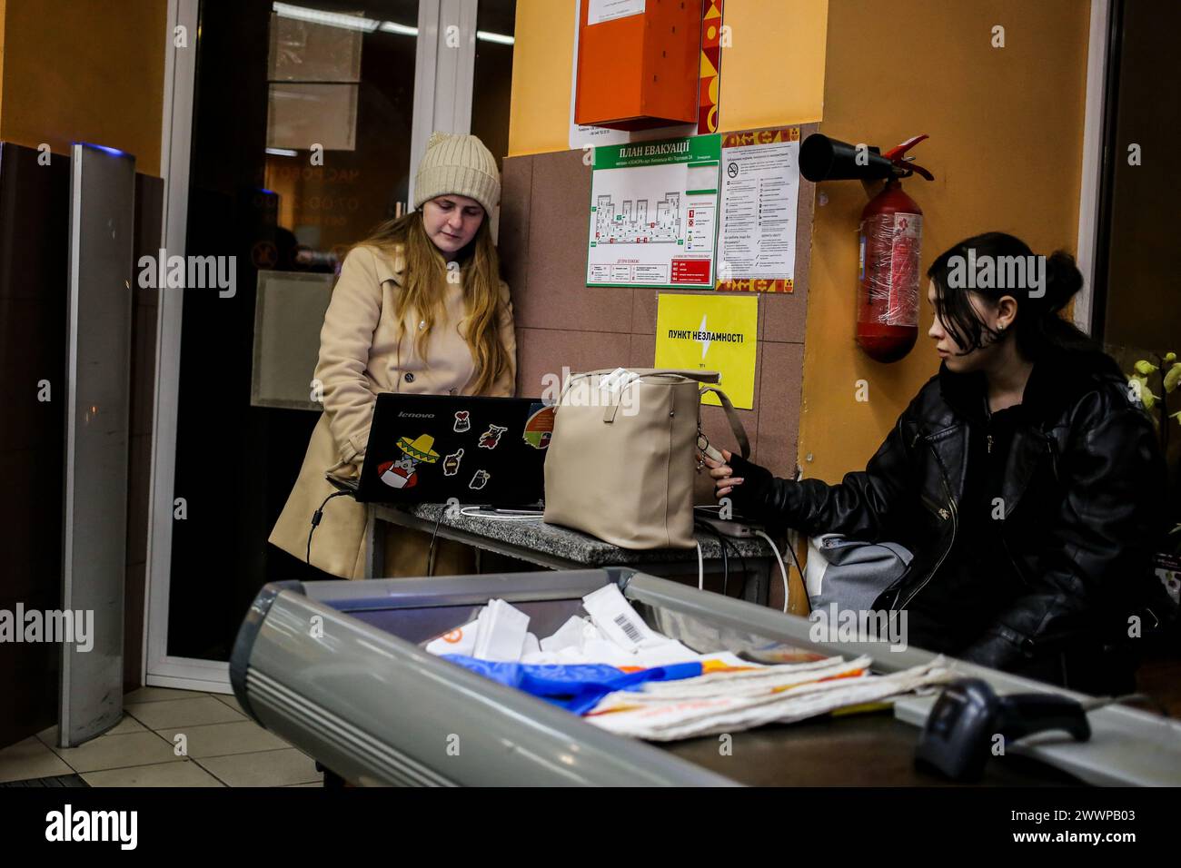 People charge their phones and computers at a grocery store on Torgovaya Street. A massive ...