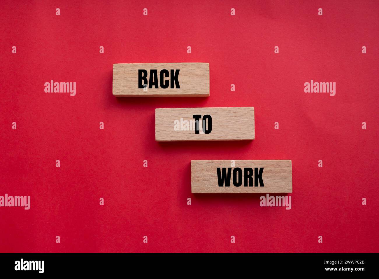 Back to work words written on wooden blocks with red background ...