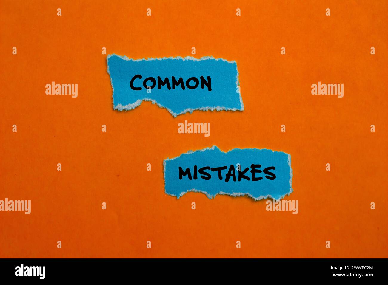Common mistakes words written on blue torn paper pieces with orange ...