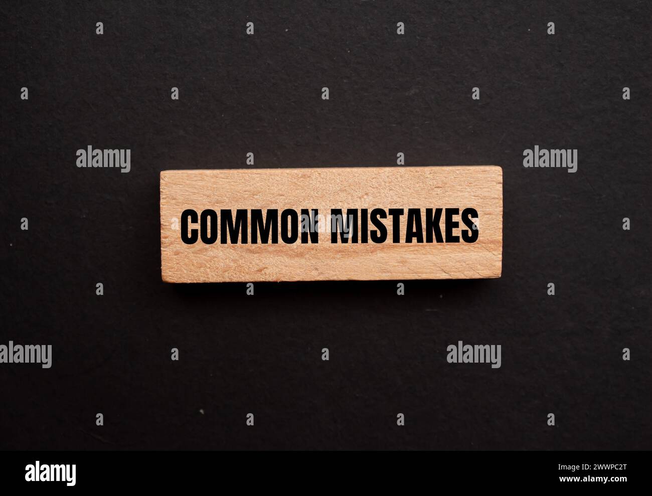 Common mistakes words written on wooden block with black background ...