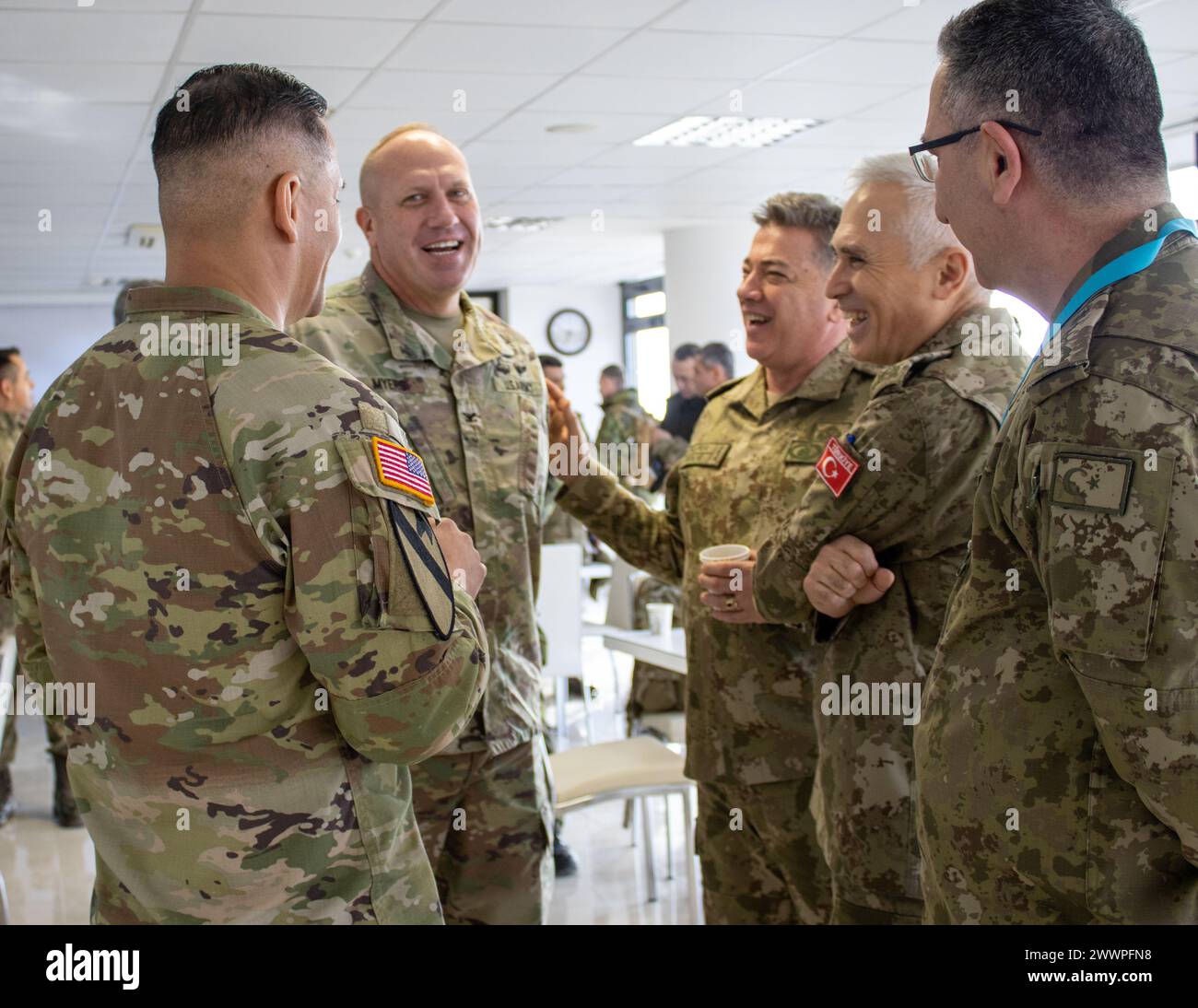 U.S. Army and Türkiye Land Forces officers speak and laugh during an ...