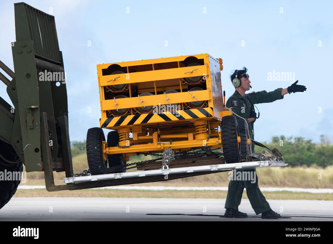 A Japan Air Self-Defense Force C-130H Hercules loadmaster directs a ...