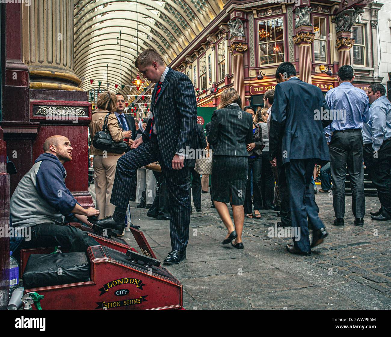 Shoe cleaner is polishing the shoes of a buissnesman in Leadenhall ...