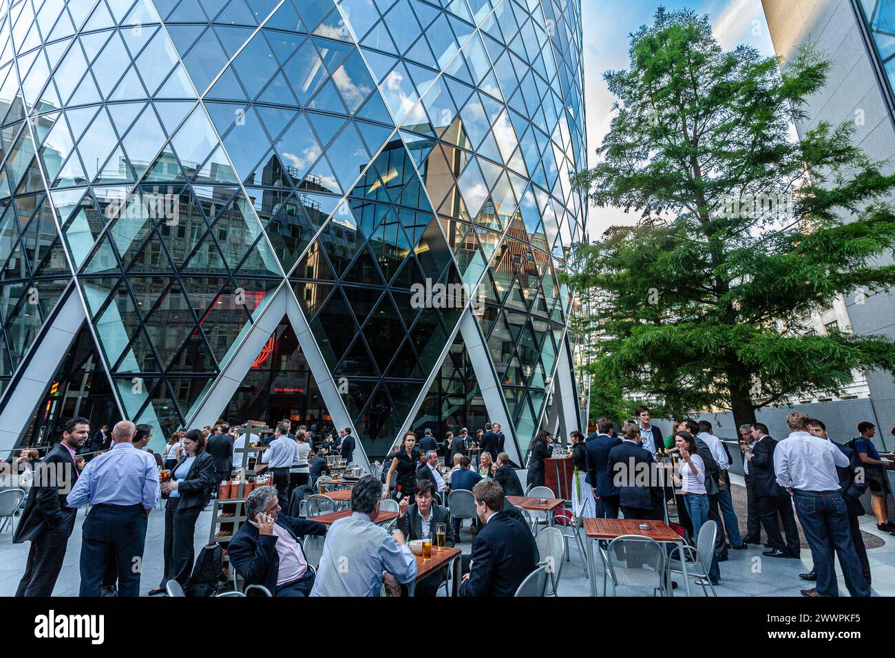 Gherkin building in the City of London with people sitting outside ...