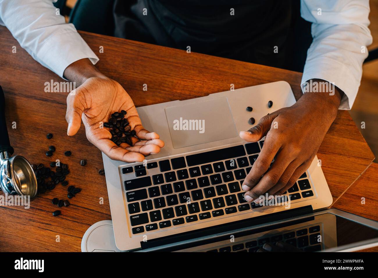 At coffee roastery the business owner and barista utilizes laptop to ...