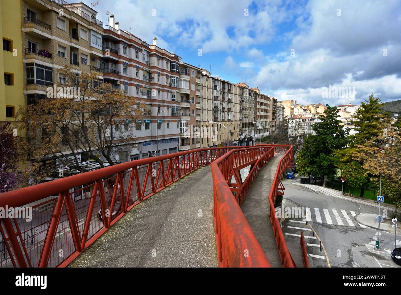 Footbridge over highway with apartments over small businesses at street ...