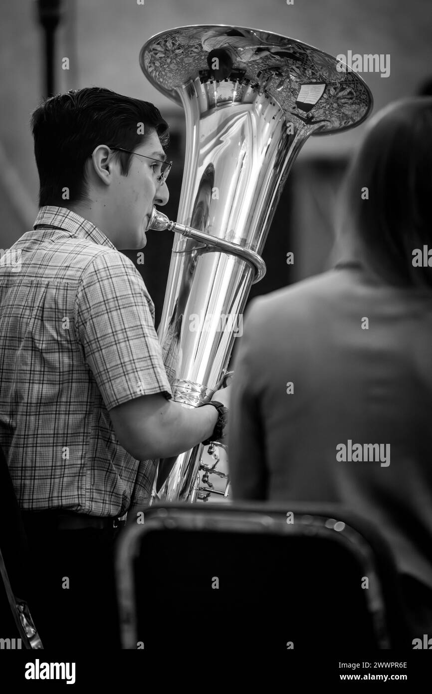 A student plays the tuba next to Carol Jantsch, who is conducting a ...