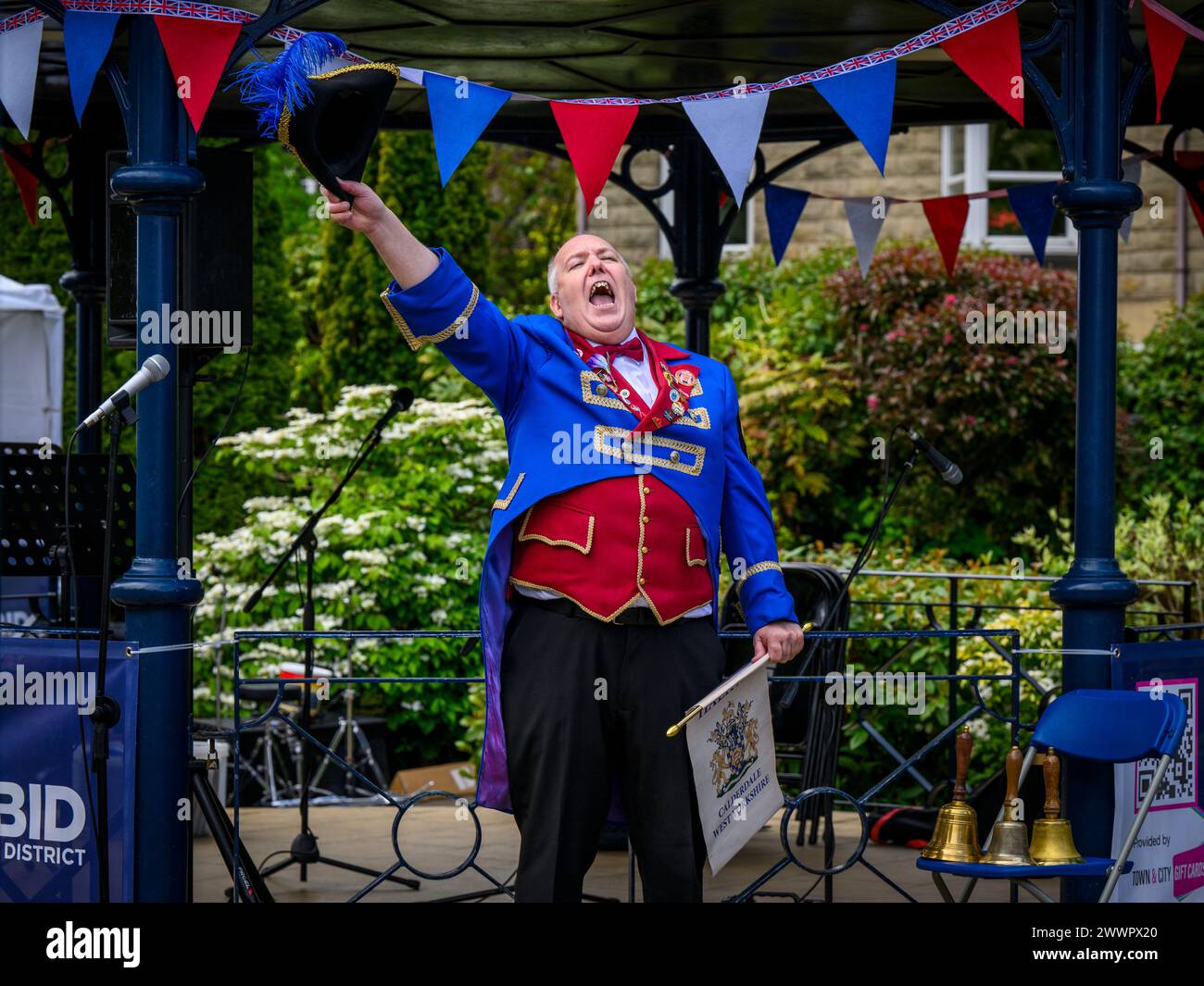 Male town crier (blue red crier's uniform, tricorne hat in hand) making ...