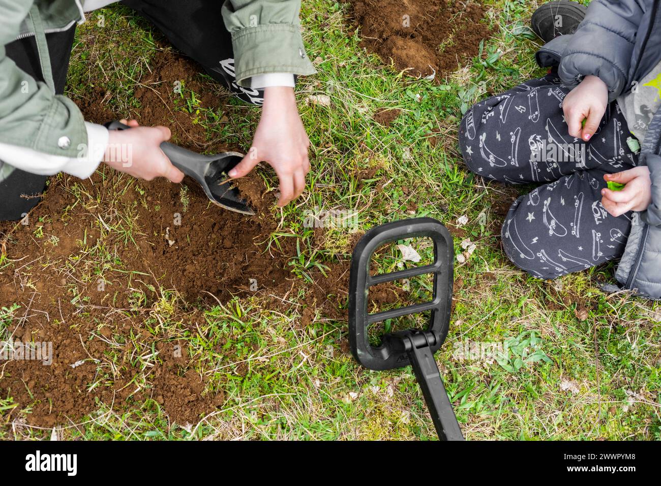 The kid treasure hunters metal detecting and digging the ground Stock ...