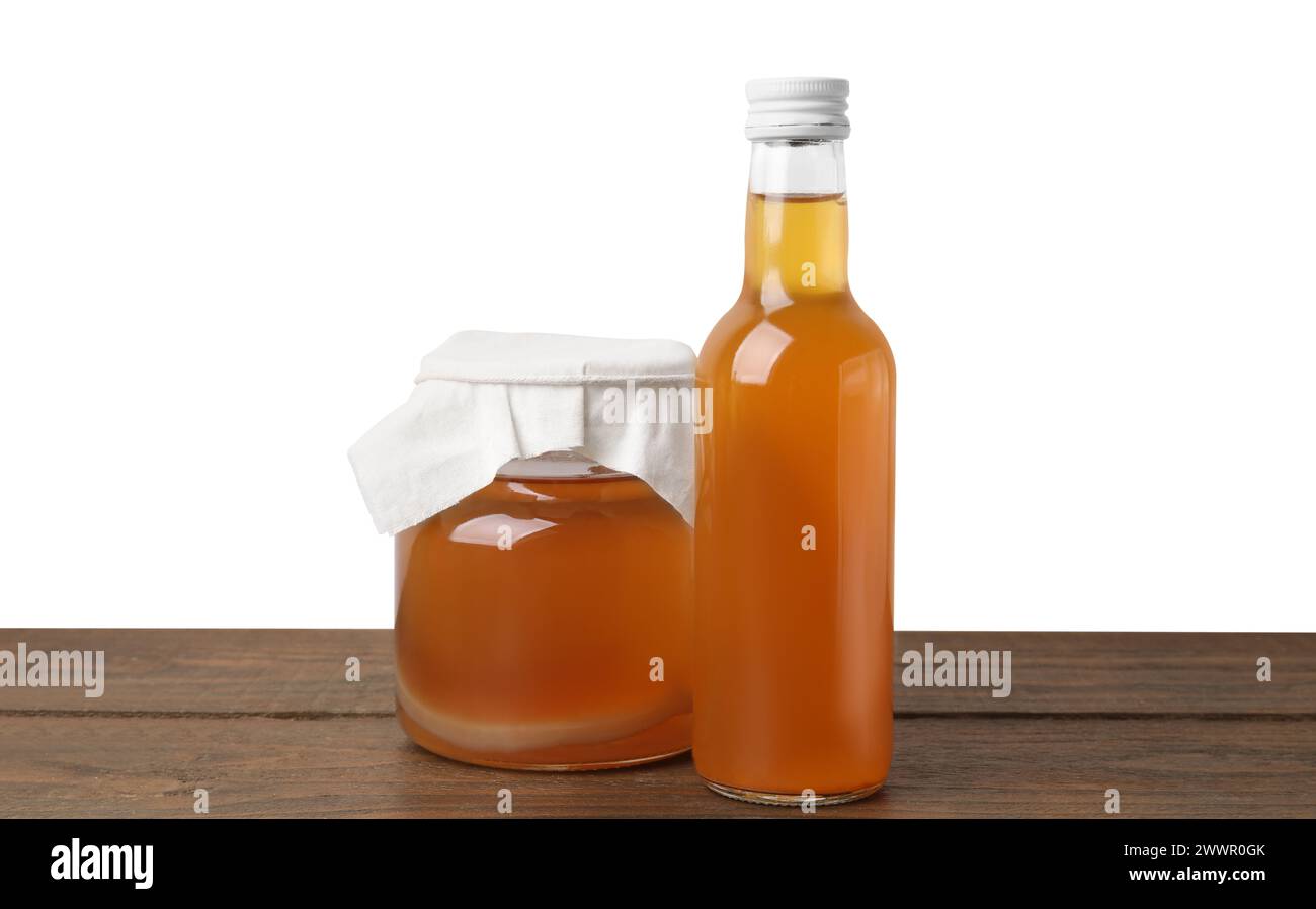 Delicious kombucha in glass bottle and jar on wooden table against ...