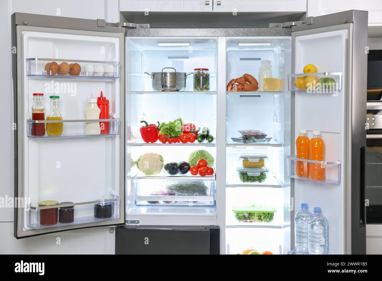 Modern open refrigerator full of different products in kitchen Stock ...