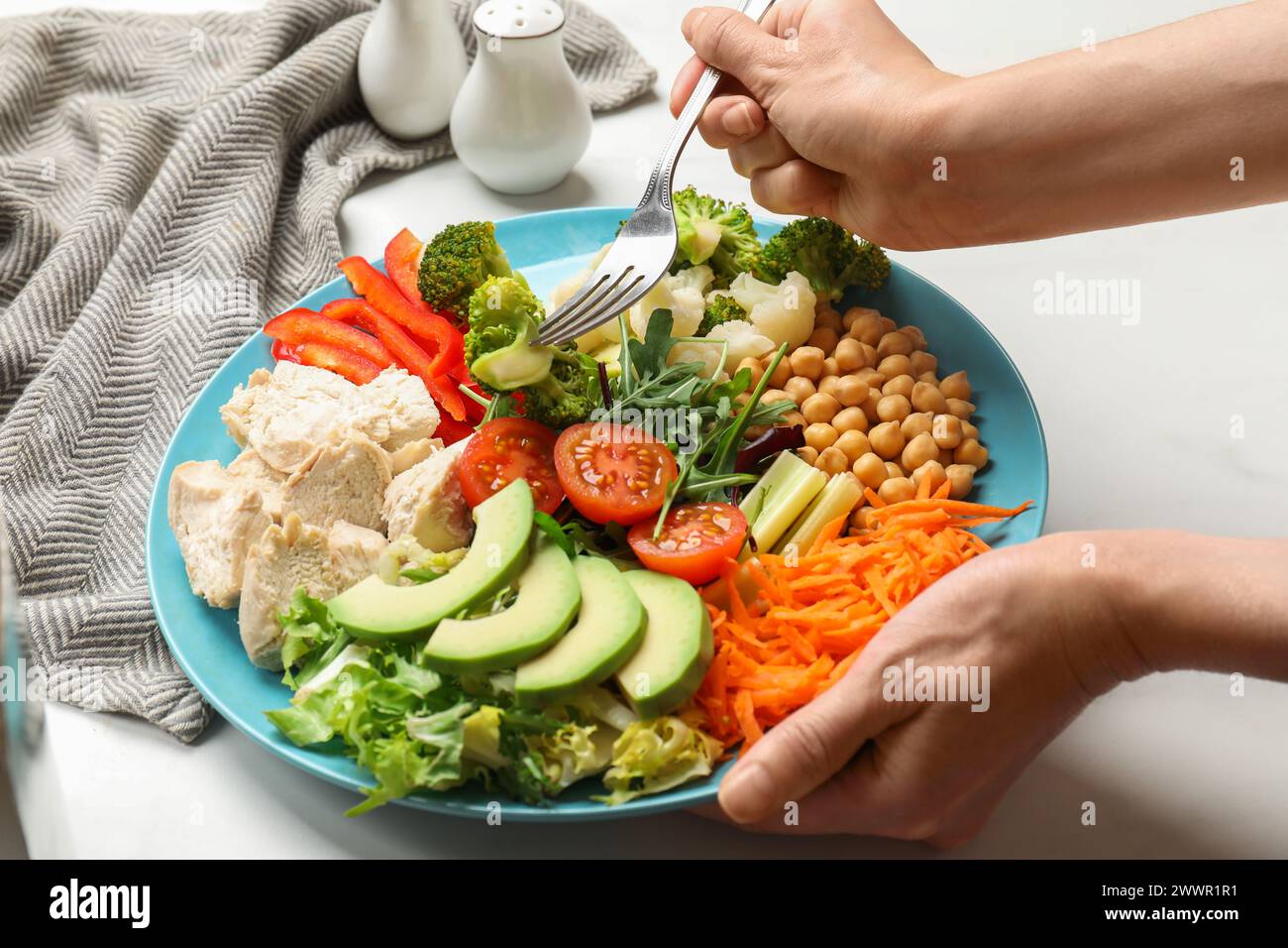 Balanced diet and healthy foods. Woman eating dinner at white table ...