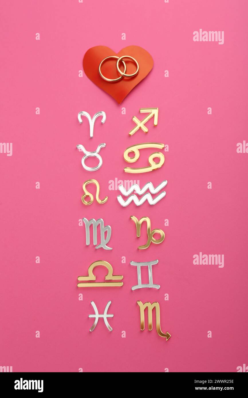 Zodiac compatibility. Signs, wedding rings and red heart on pink ...