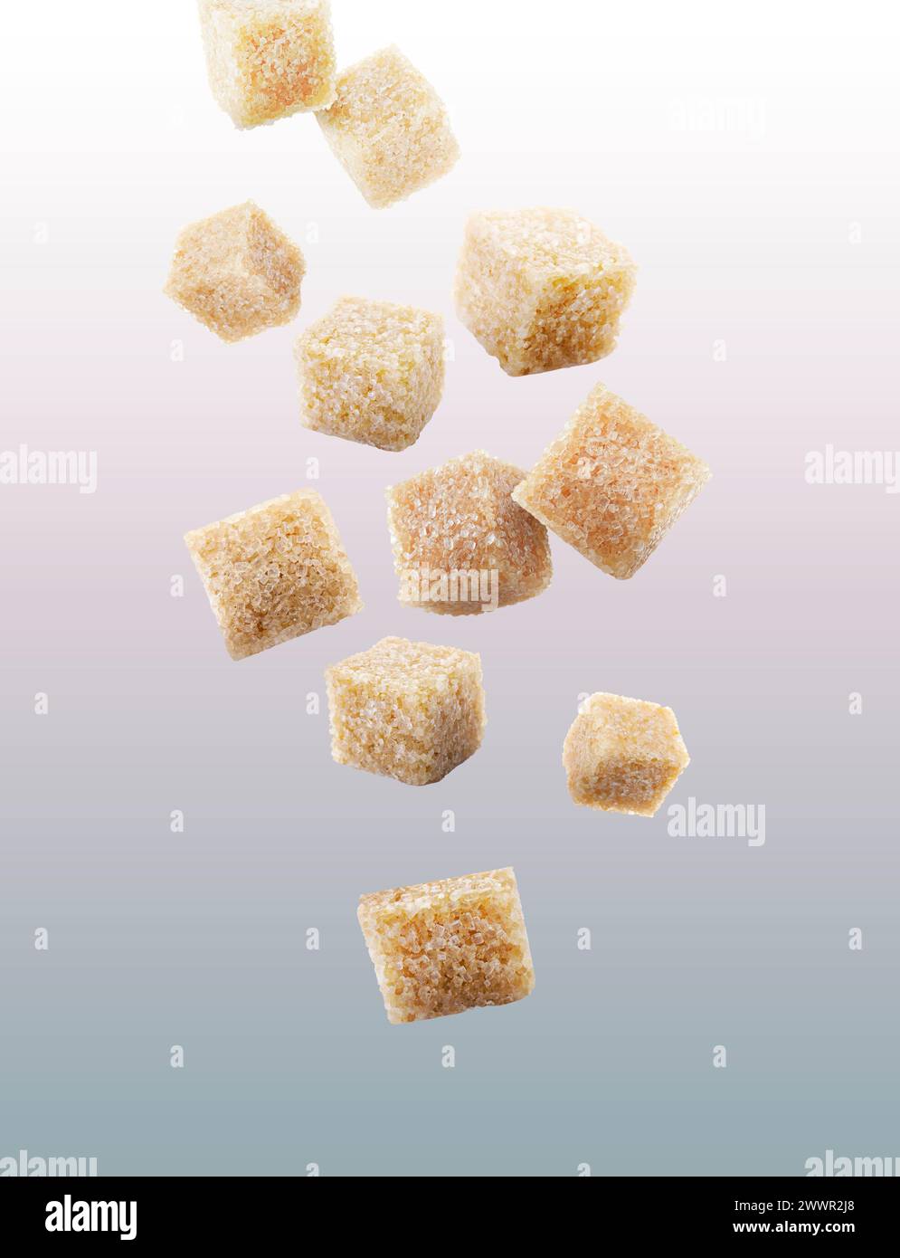 Brown cane sugar cubes falling on grey gradient background Stock Photo ...