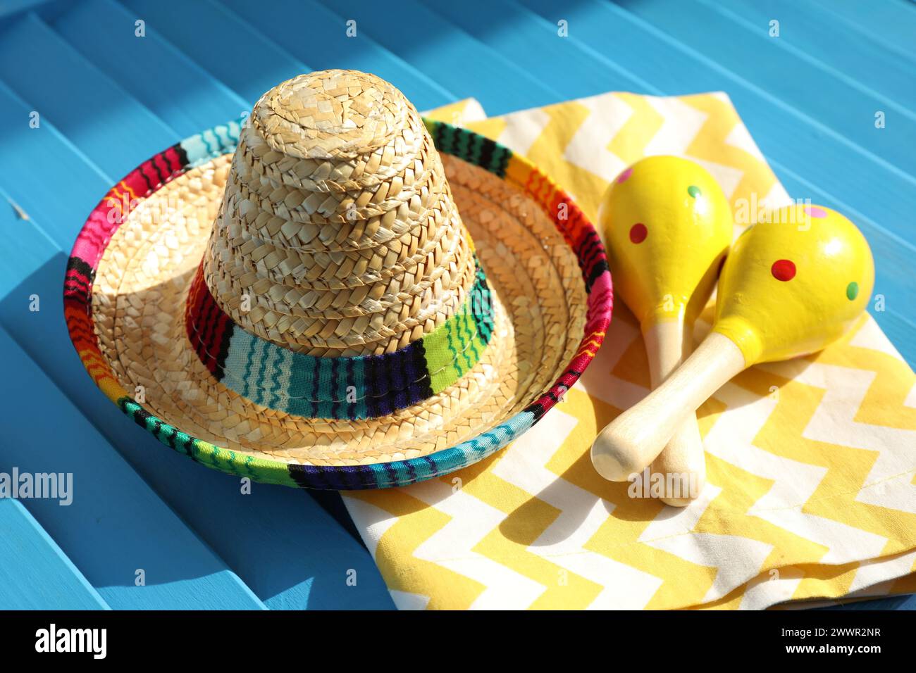 Mexican sombrero hat, towel and maracas on blue wooden surface Stock ...