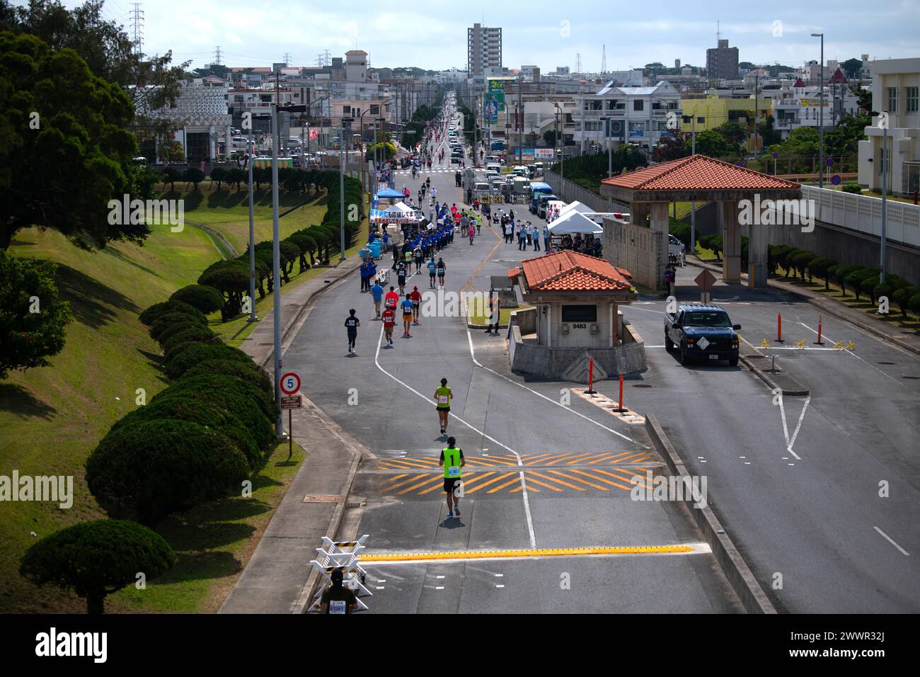 Runners exit through gate 5 during the Okinawa Marathon at Kadena Air ...