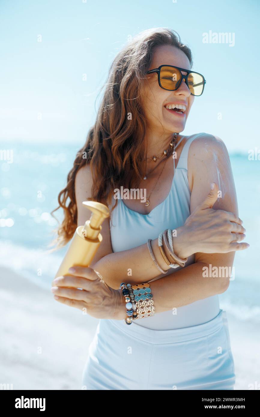 happy elegant woman on the beach with spf Stock Photo - Alamy