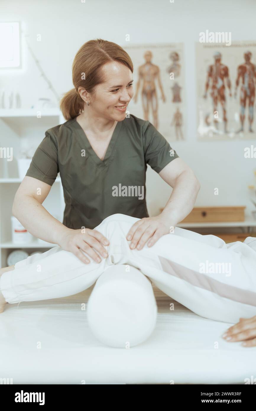 Healthcare time. smiling female massage therapist in massage cabinet with client doing checkup ...