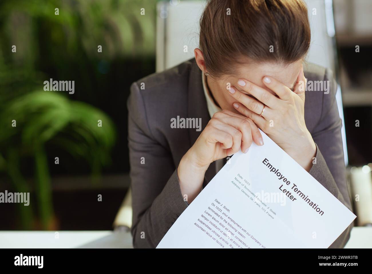 New job. Closeup on modern woman worker in modern green office in grey ...