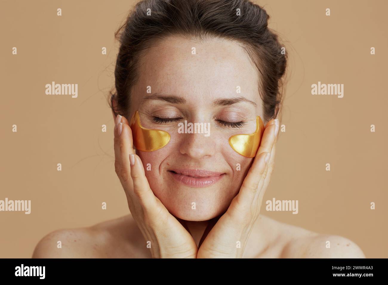 relaxed modern woman with eye patches on beige background Stock Photo ...