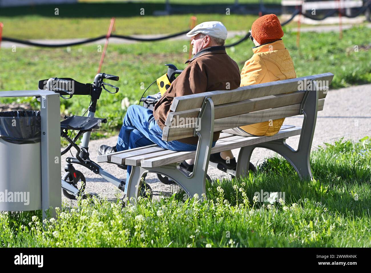 Altes Ehepaar-Rentner -Mann und Frau mit Rollator sitzen auf einer Bank ...