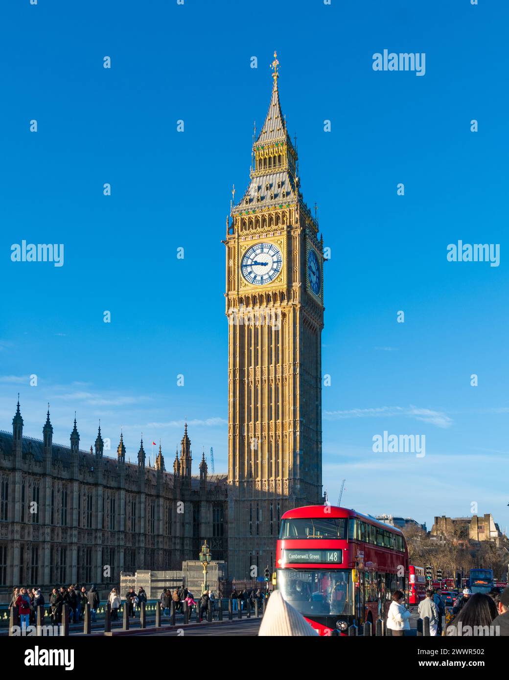 Iconic red double-decker bus passing by Big Ben and the Houses of ...