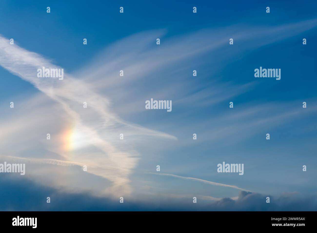 Sky with cirrus, stratus clouds, airplane trail and halo from the sun ...