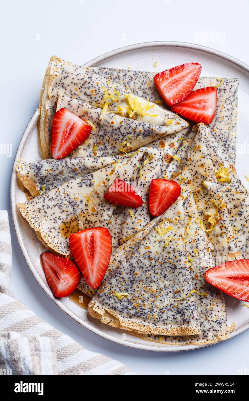 Crepes with poppy seeds, maple syrup and strawberries, top view ...