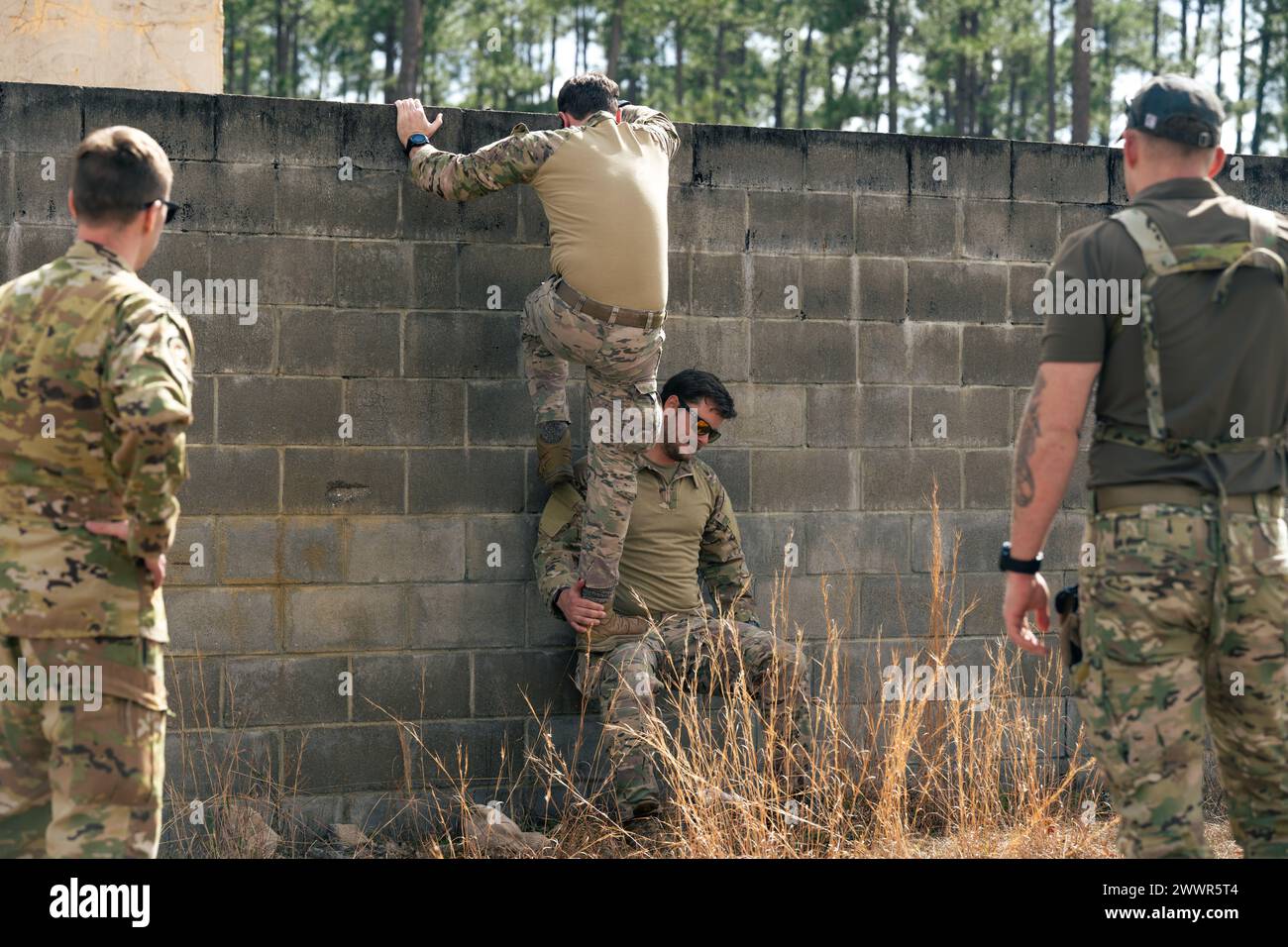 U.S. Air Force Air Commandos climb a wall during a survival, escape ...
