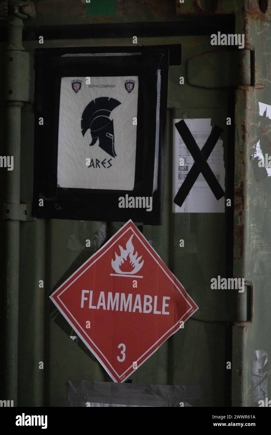 A flammable warning sign is displayed on a quadcon while loading onto ...
