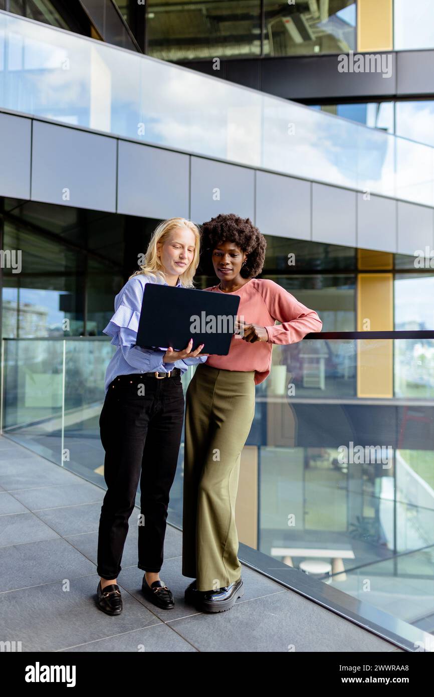 Two women with similar features stand side by side, smiling, in front ...