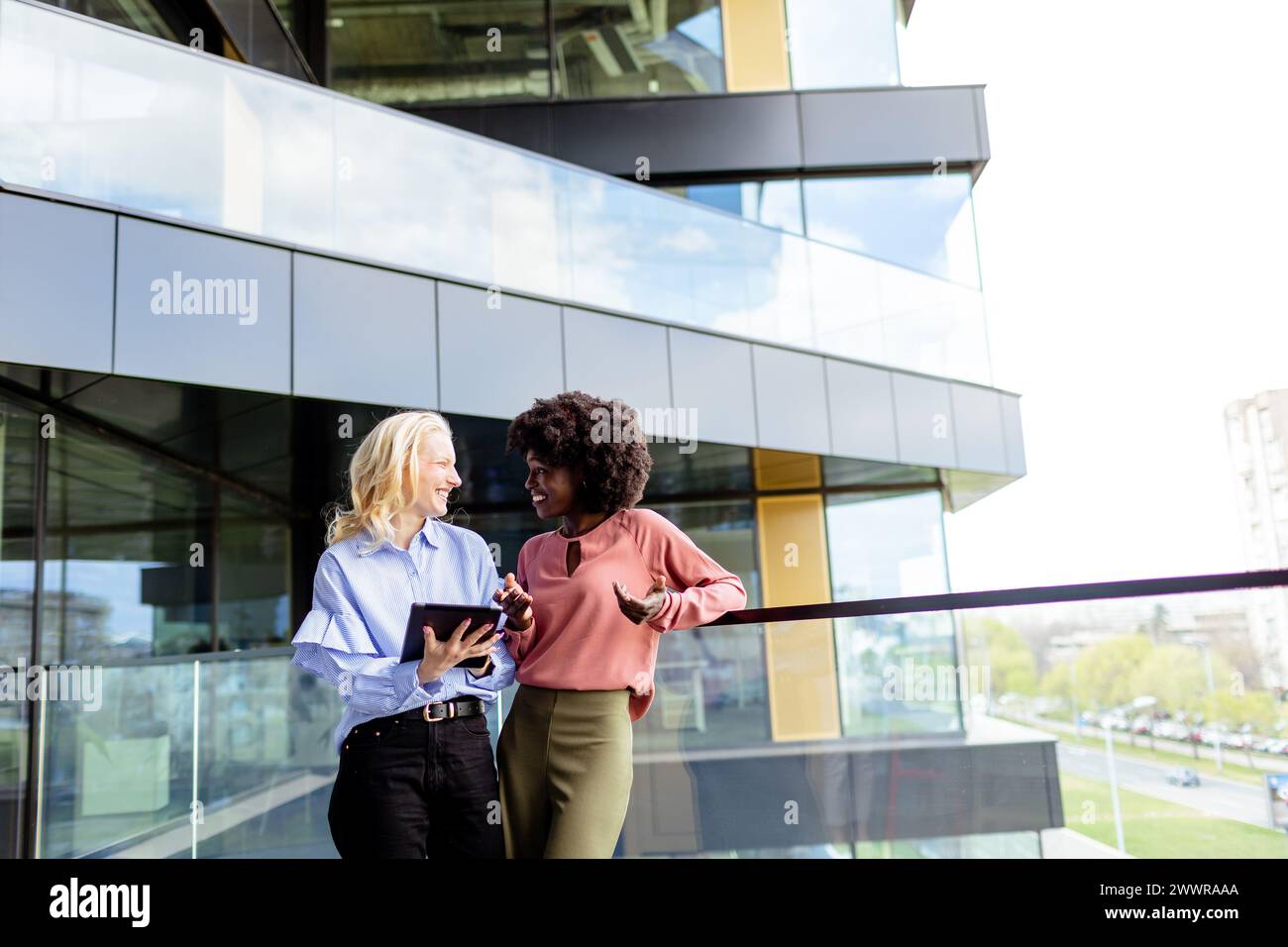 Two women with similar features stand side by side, smiling, in front ...