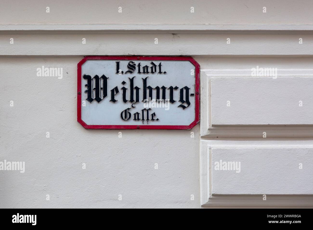A sign with the name of the street in Gothic script in the center of ...