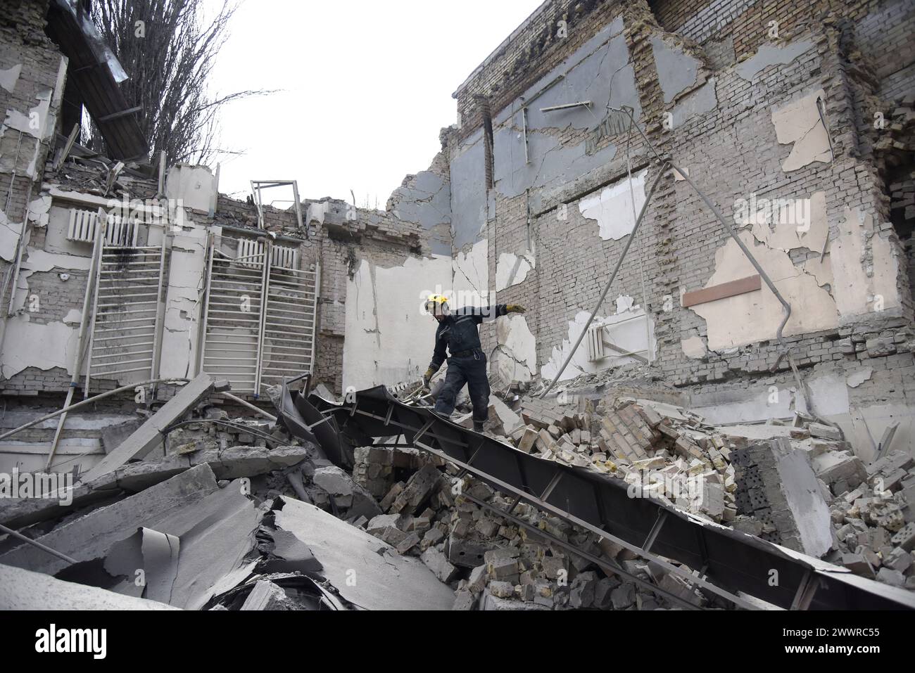 KYIV, UKRAINE - MARCH 25, 2024 - A rescuer examines the rubble at an ...