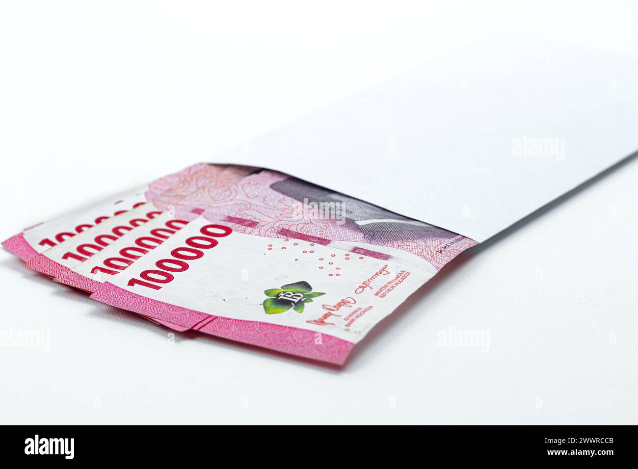 Indonesian rupiah currency. White envelope containing IDR 100,000 in ...