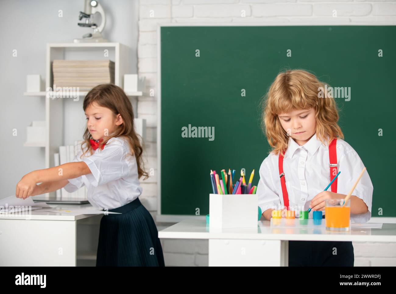 Cute school friends kids drawing and painting at school. Friendly boy ...