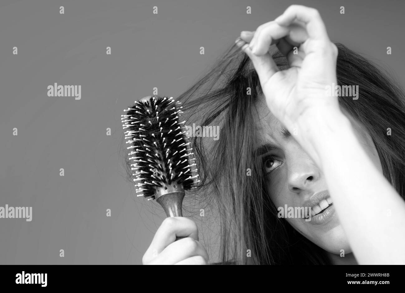 Sad woman looking at damaged hair, the hair loss problem. Studio ...
