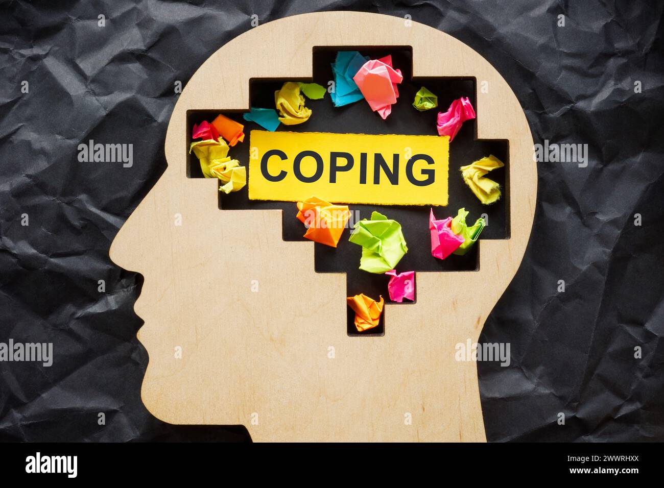 Head on a dark surface with an inscription coping and colored paper ...