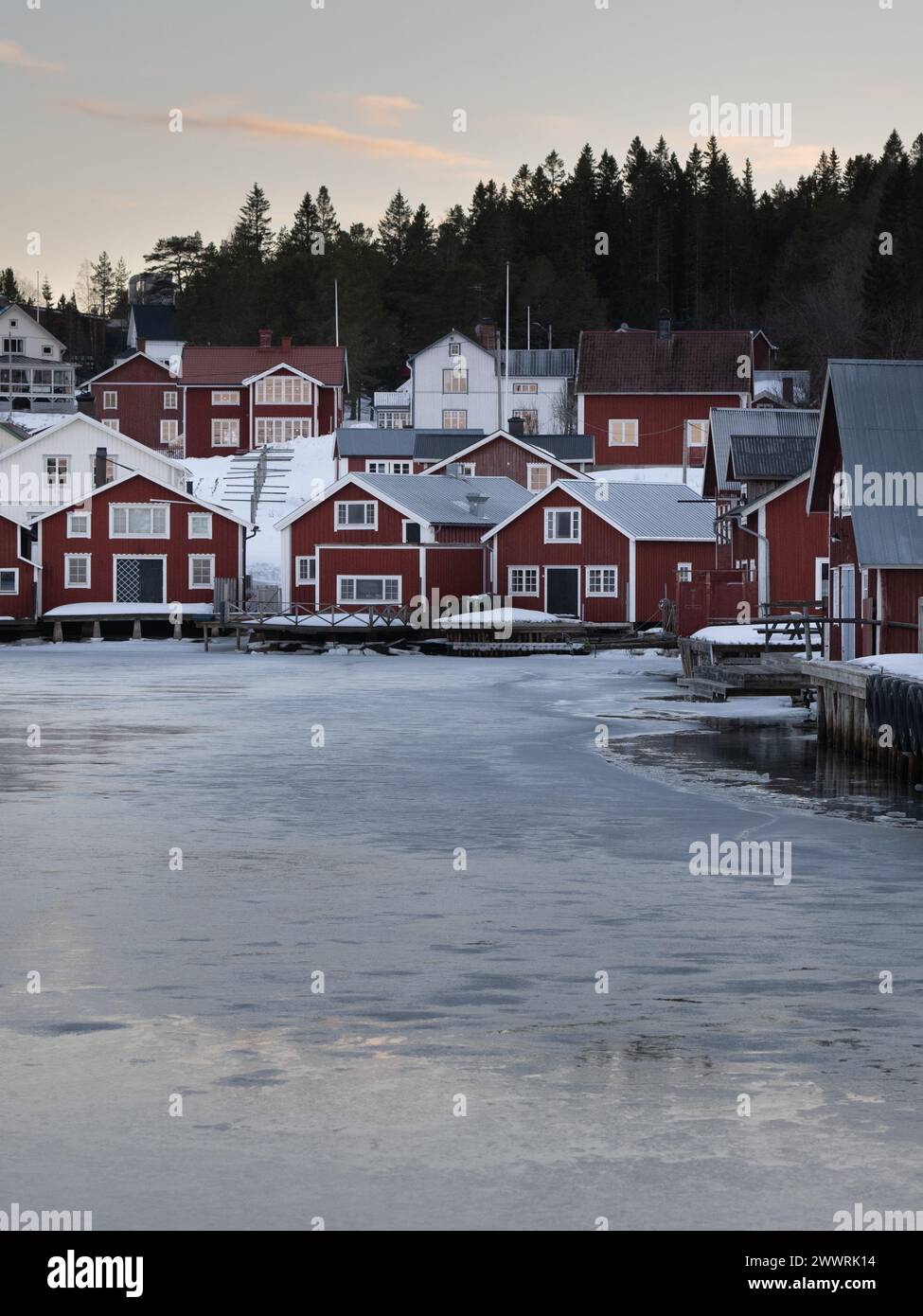 Snowy harbor with numerous houses and a dock Stock Photo - Alamy