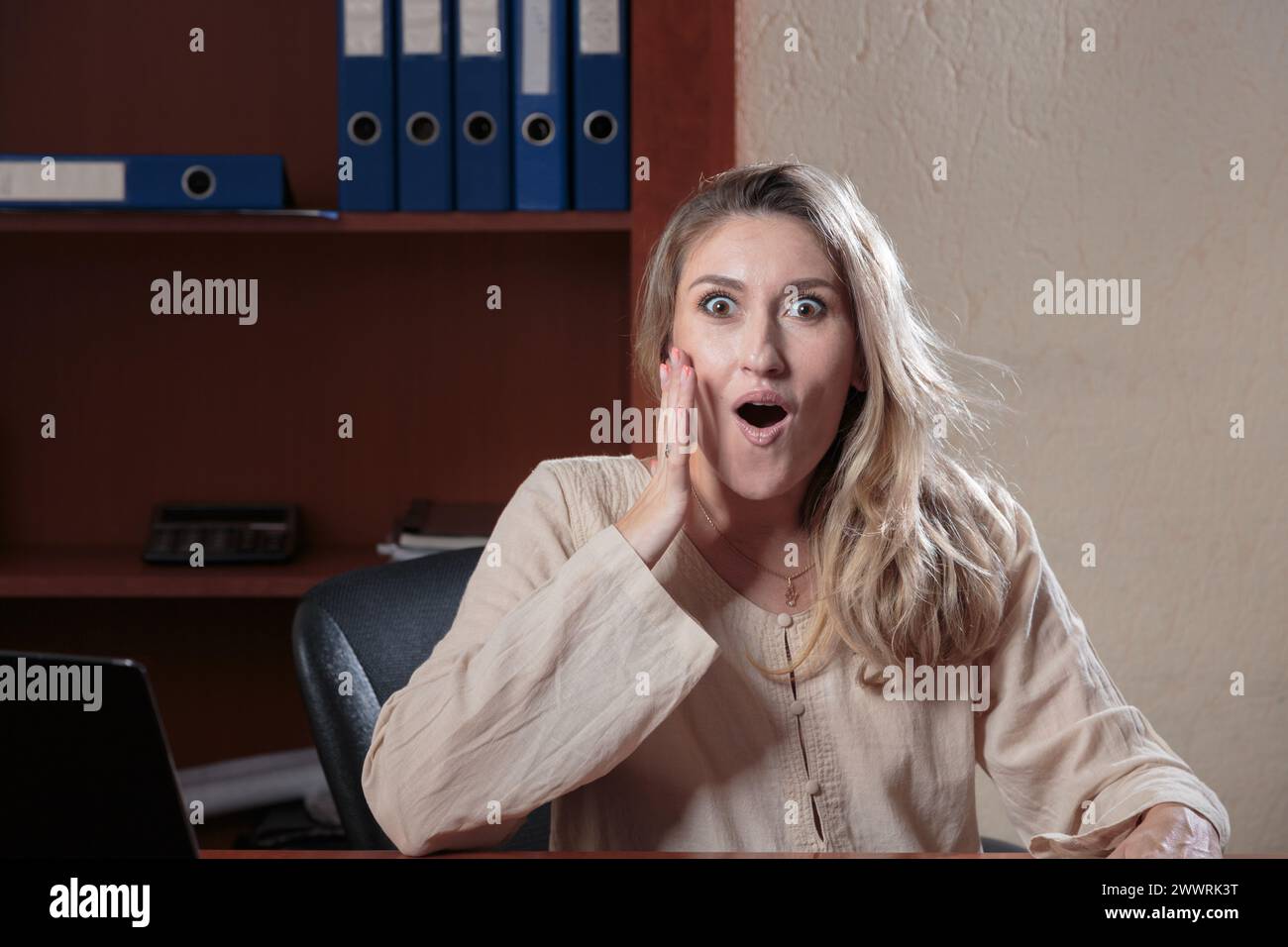 Female emotional portrait in the office. The woman is very surprised ...