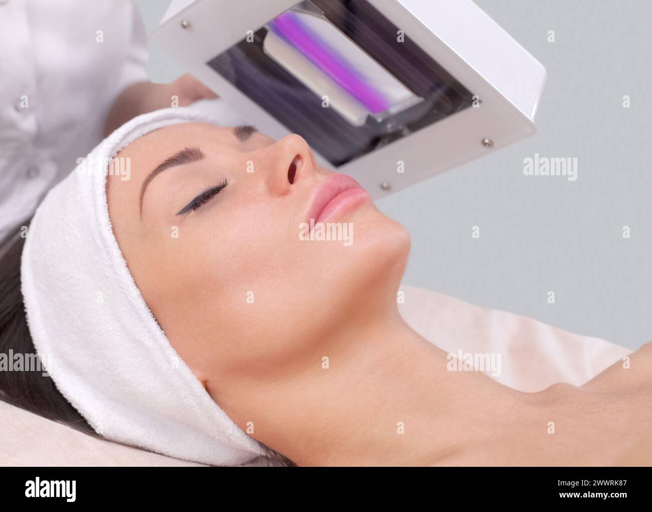 The cosmetologist uses the Wood Lamp for detailed diagnosis of the skin ...